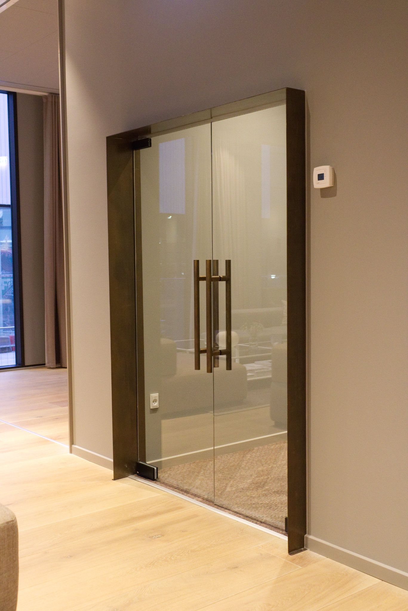 Puerta sencilla en vidrio templado con chapeta hidráulica – instalada